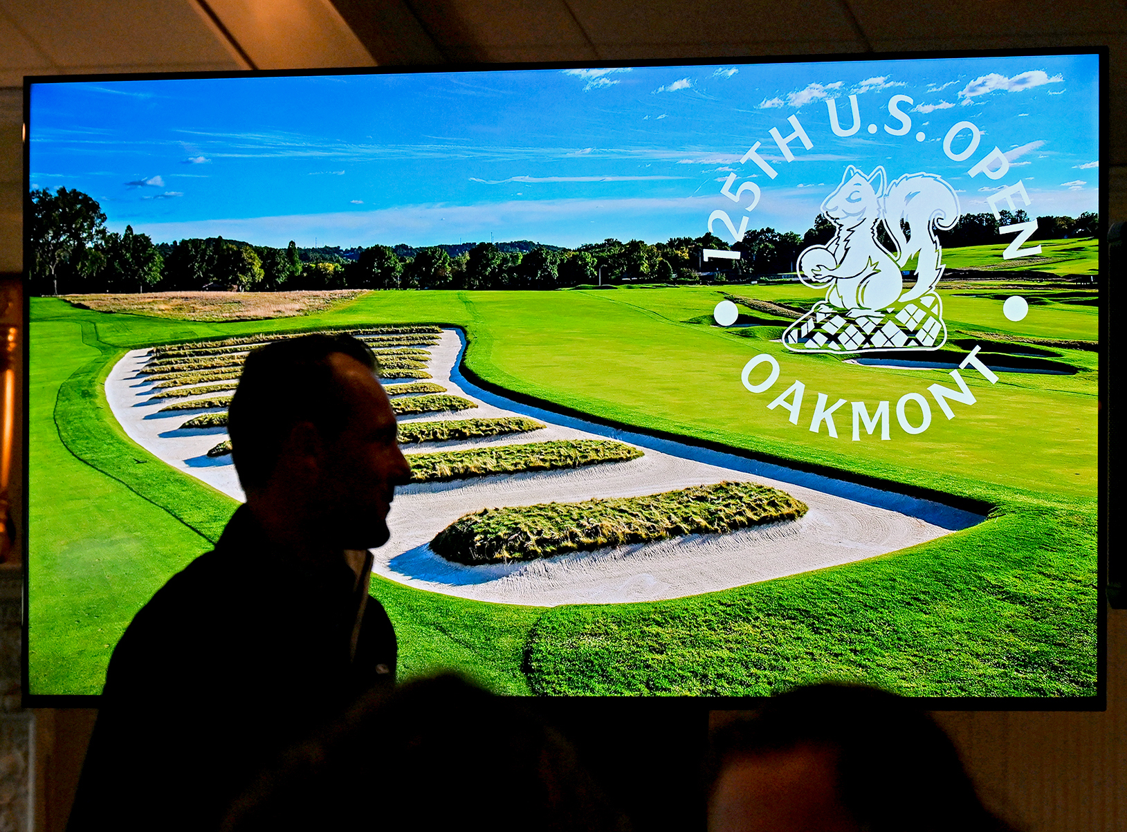 A maintenance worker digs a hole on a green during U.S. Open Media Day ...